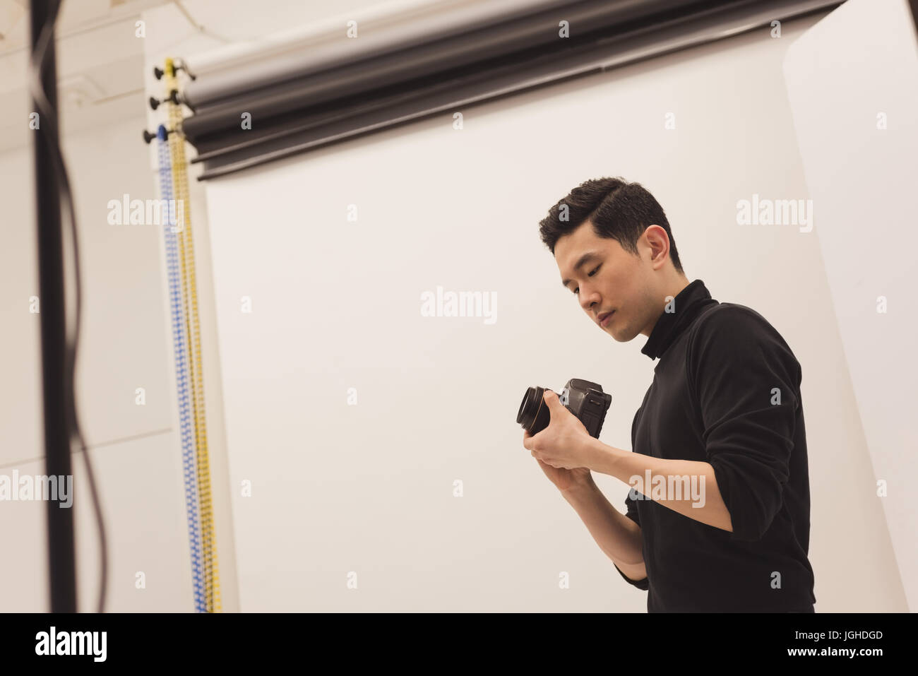 Photographer adjusting camera at studio Stock Photo - Alamy