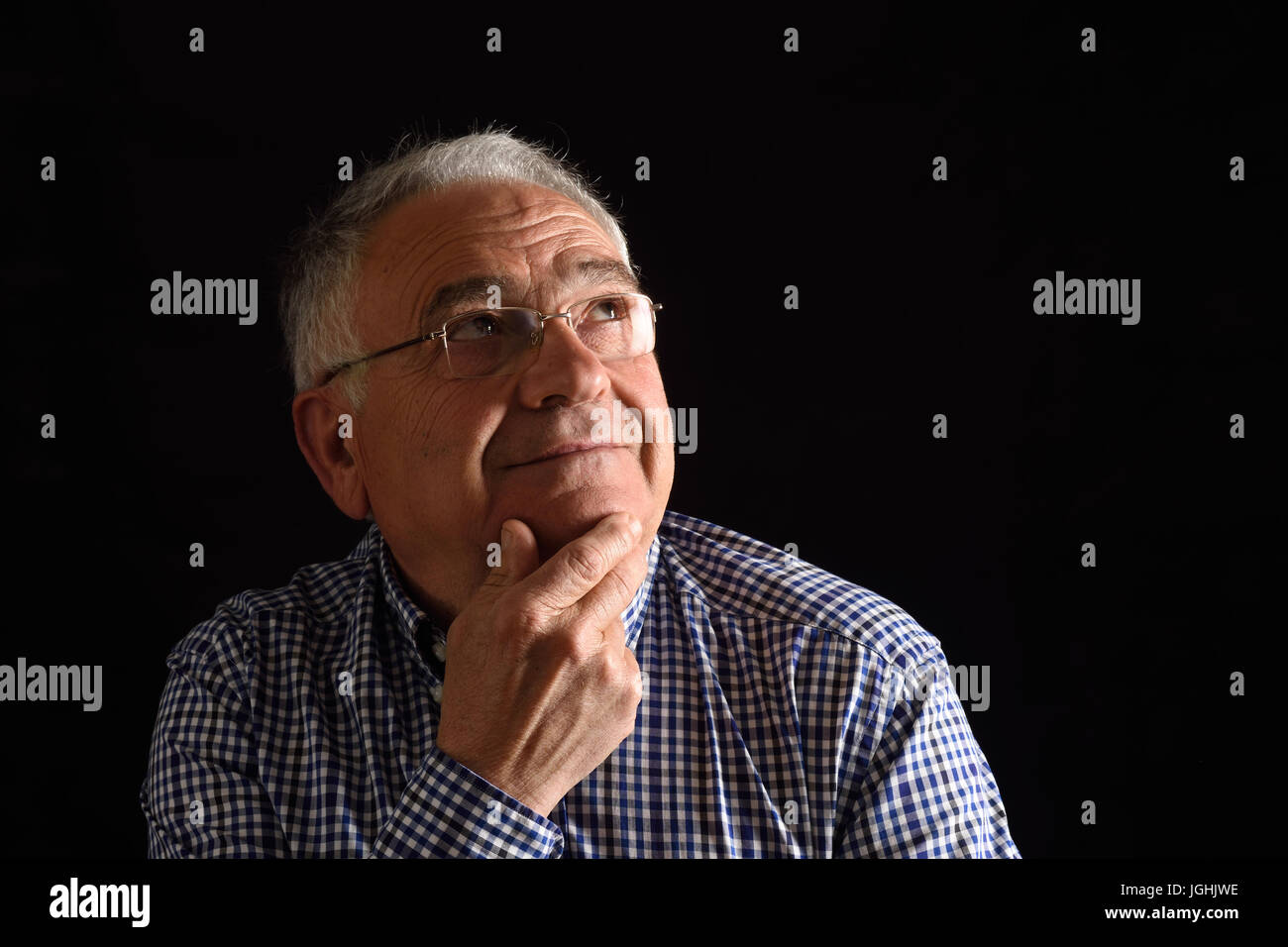 Pensative man on black background Stock Photo - Alamy