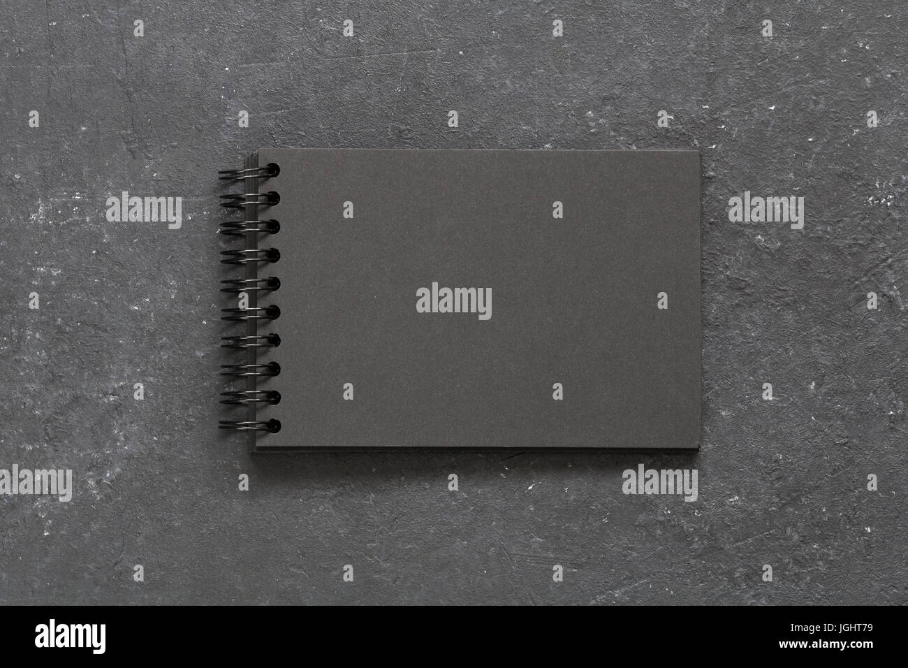 Top view on the empty black notepad on the black table. Copy space ...