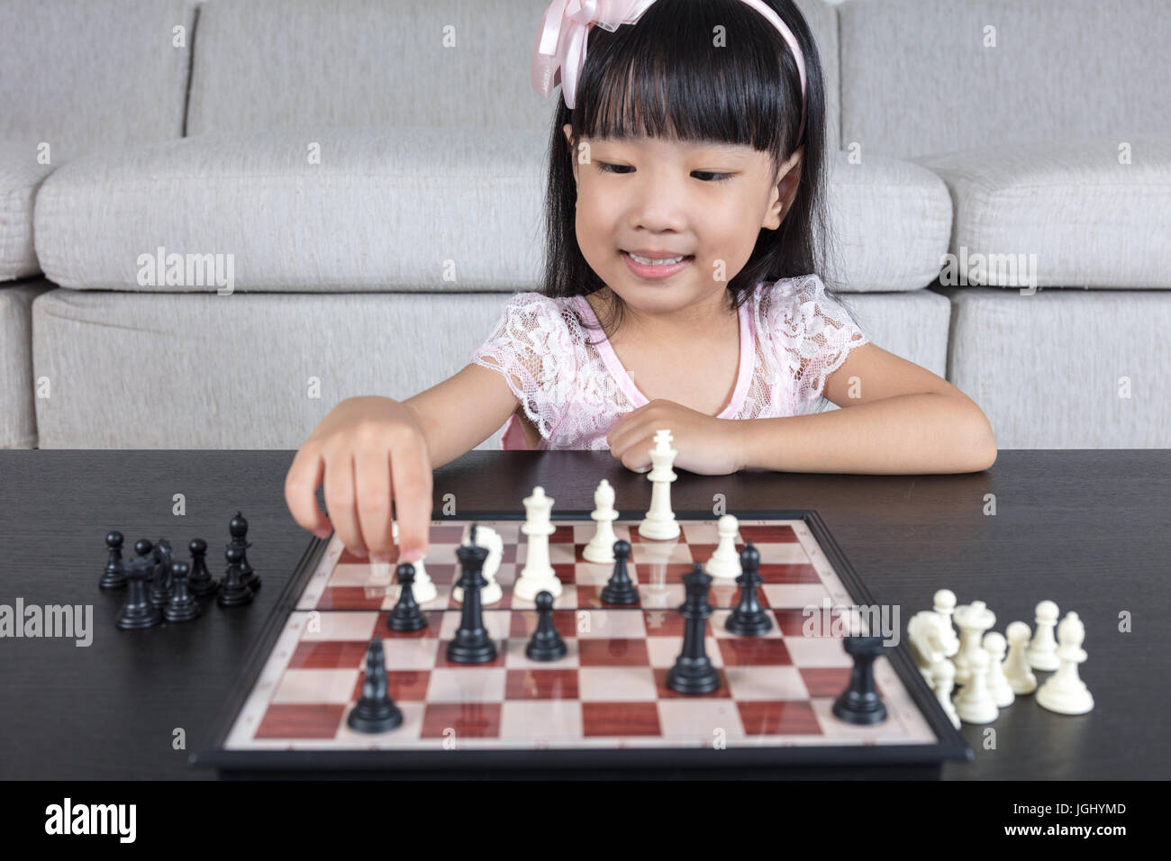 Happy Asian Chinese little girl playing chess chess in the living room ...