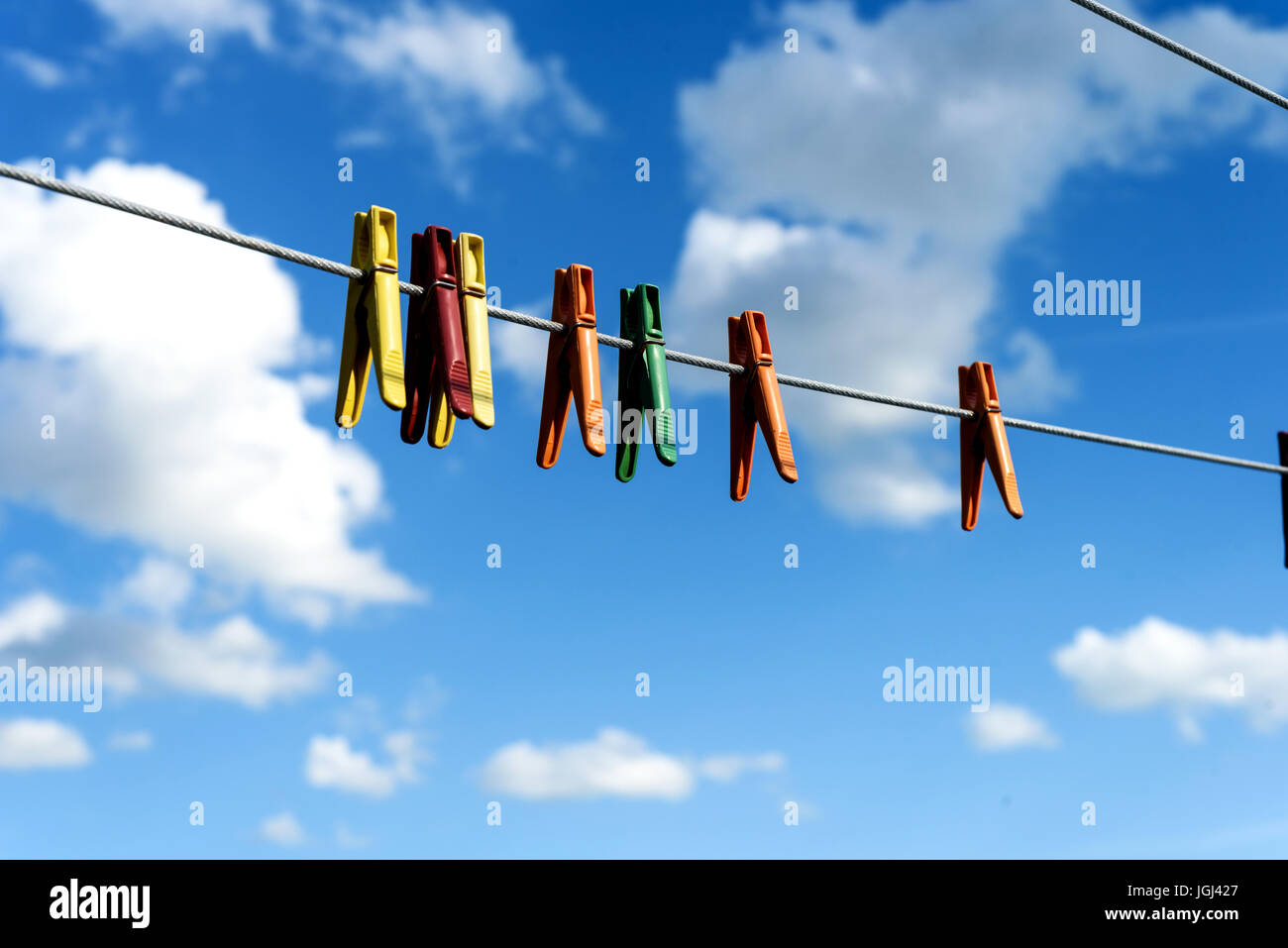 An assortment of brightly colored washing pegs and clothespins on a ...