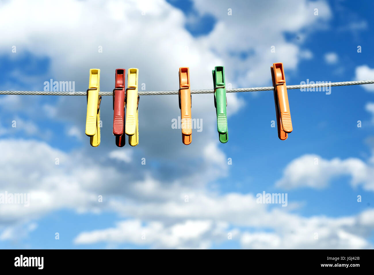 An assortment of brightly colored washing pegs and clothespins on a ...