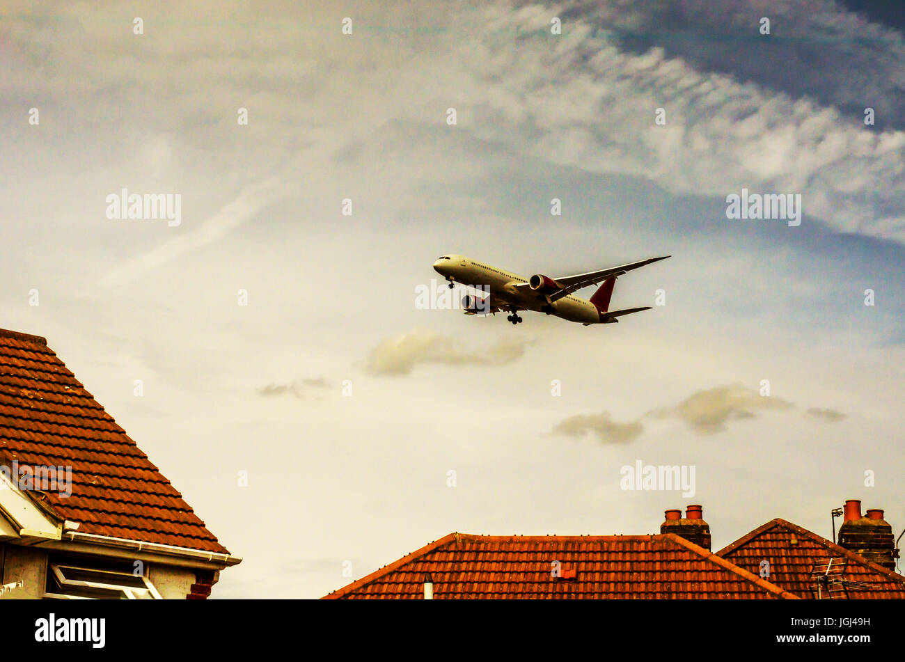 Passenger plane flying over the roofs of residential homes, low ...