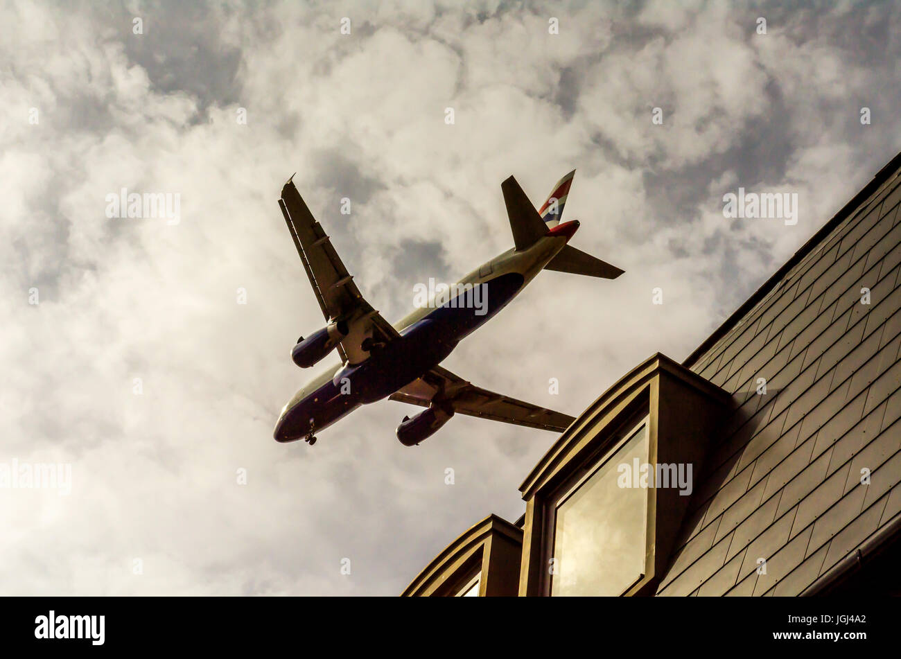 Passenger plane flying over the roofs of residential homes, low ...