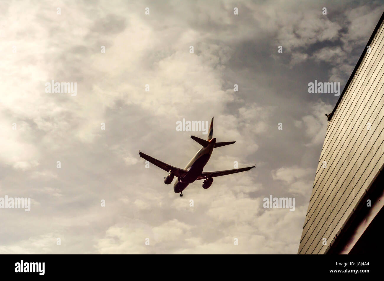 Passenger plane flying over the roofs of residential homes, low ...