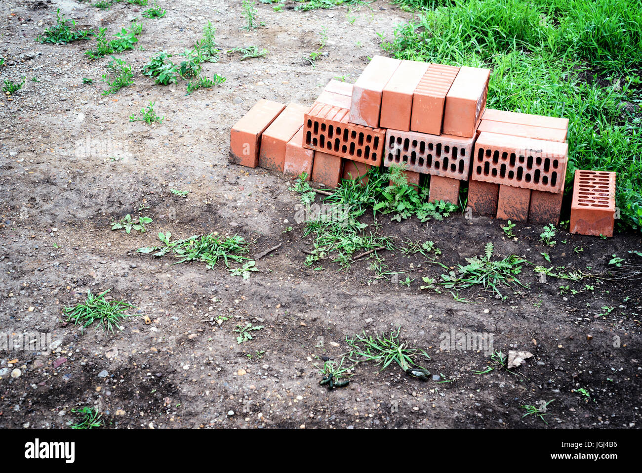 Pile of red construction bricks forgotten and left abandoned on a ...