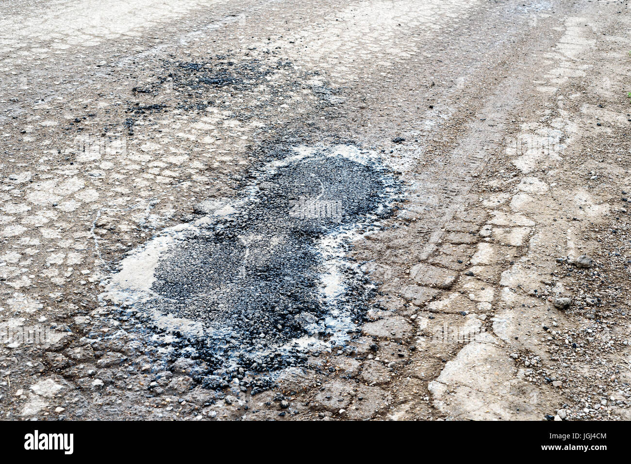 Black poured tar marks the pothole areas of a road so the holes in the ...
