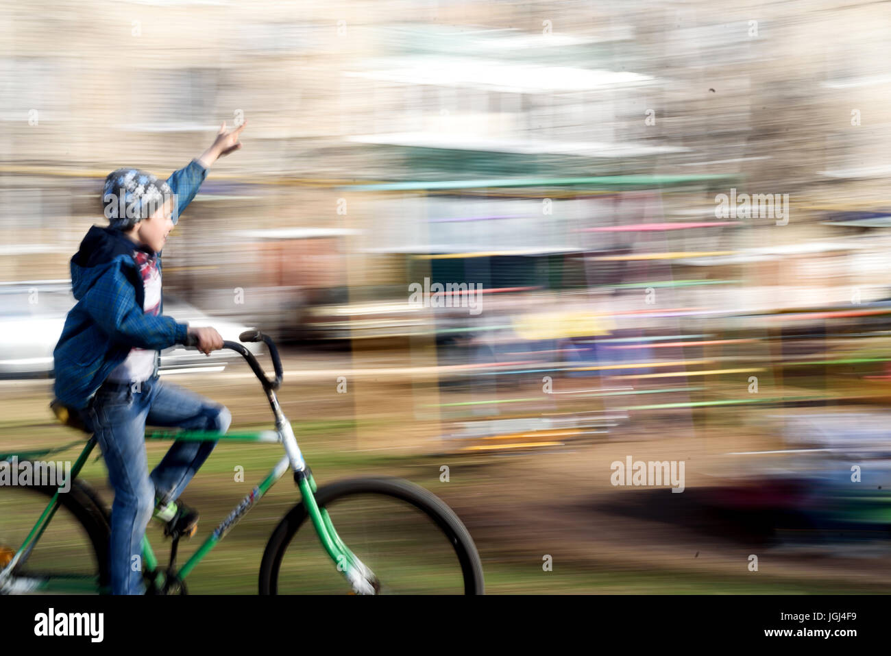 Young boy rides his bike with intentional motion blur and movement as ...