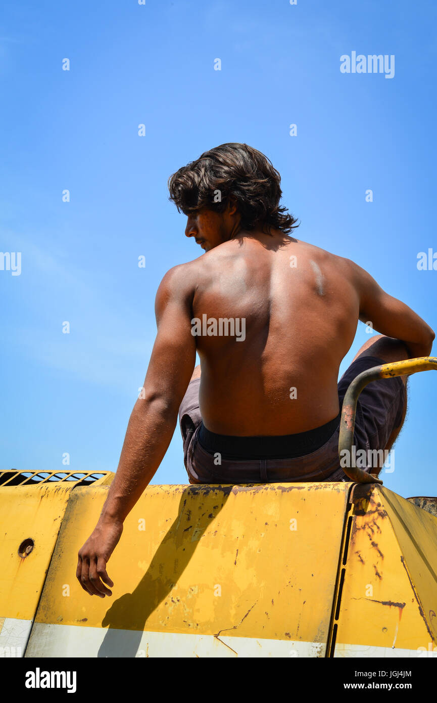 Indian worker sitting on bulldozer at relaxing hour in the construction ...