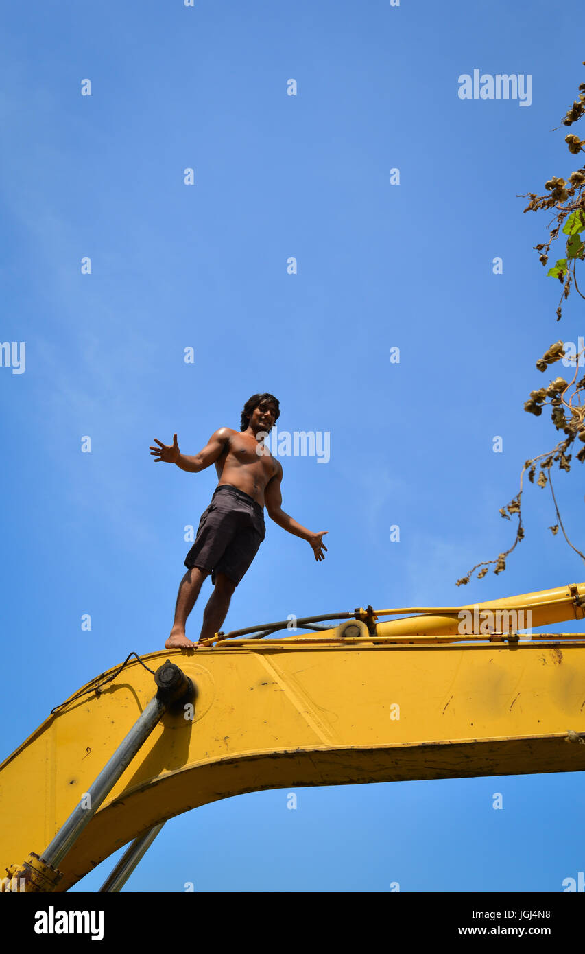 An Indian young man standing on the construction machine Stock Photo ...