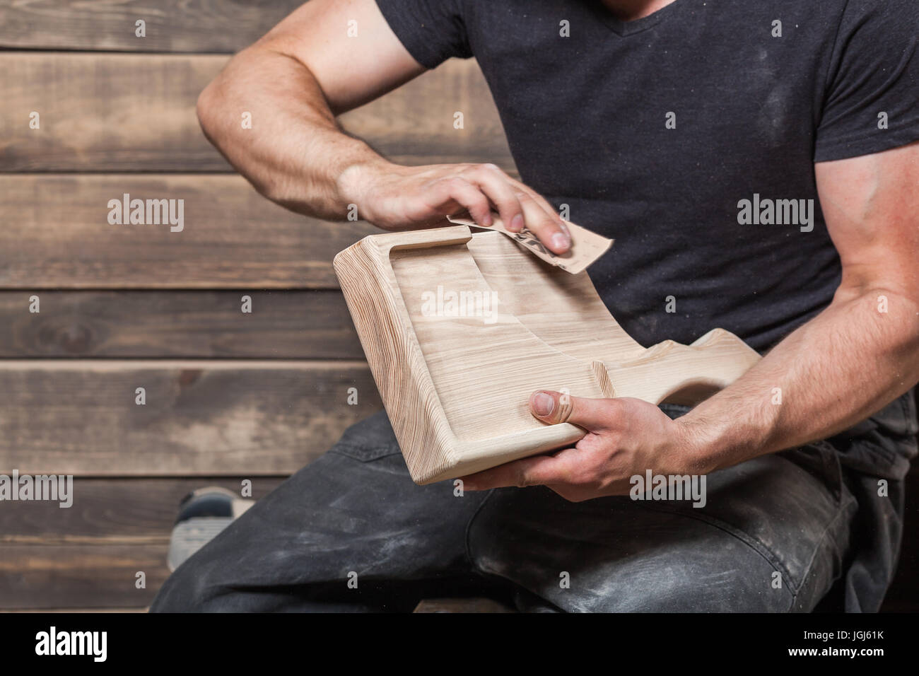Close-up of a young male carpenter leveling a wooden product in a ...