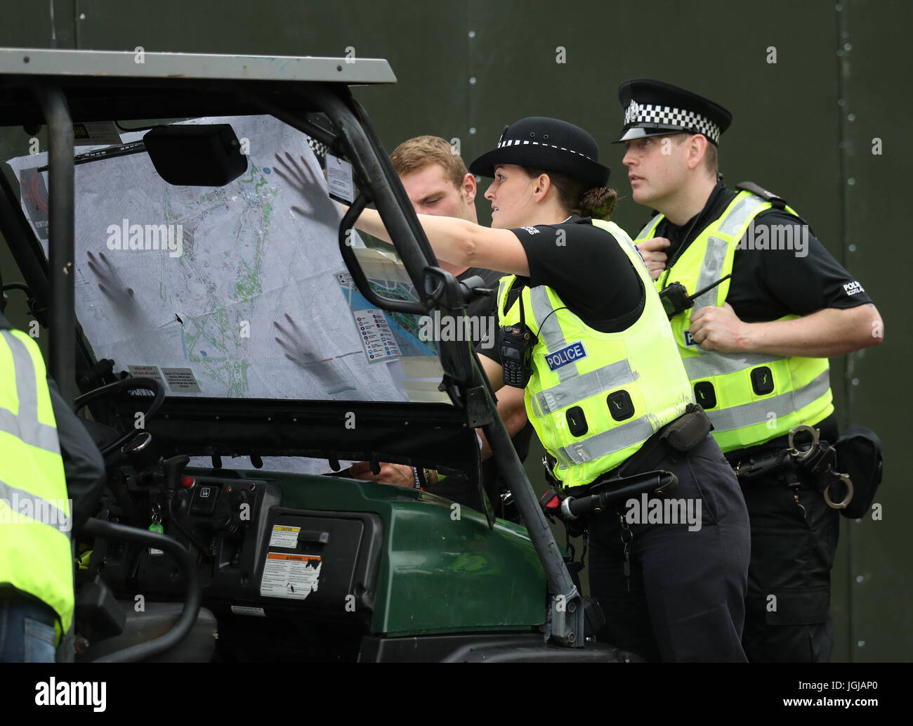 Police officers examine a map of the site as fans arrive for the ...