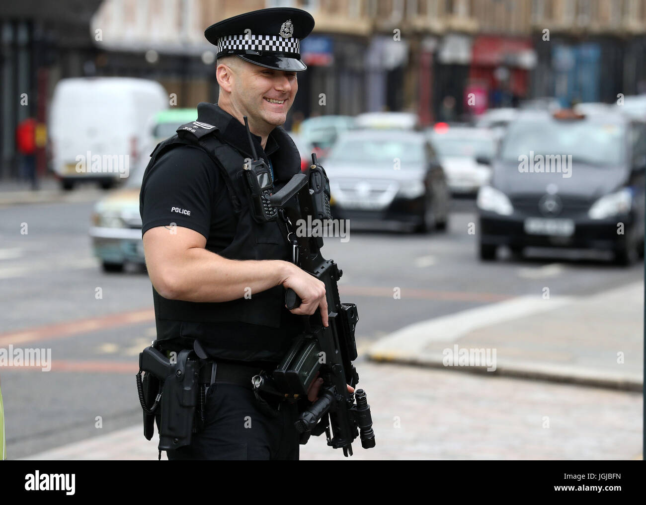An armed police officer on duty near Glasgow Green as fans arrive for ...