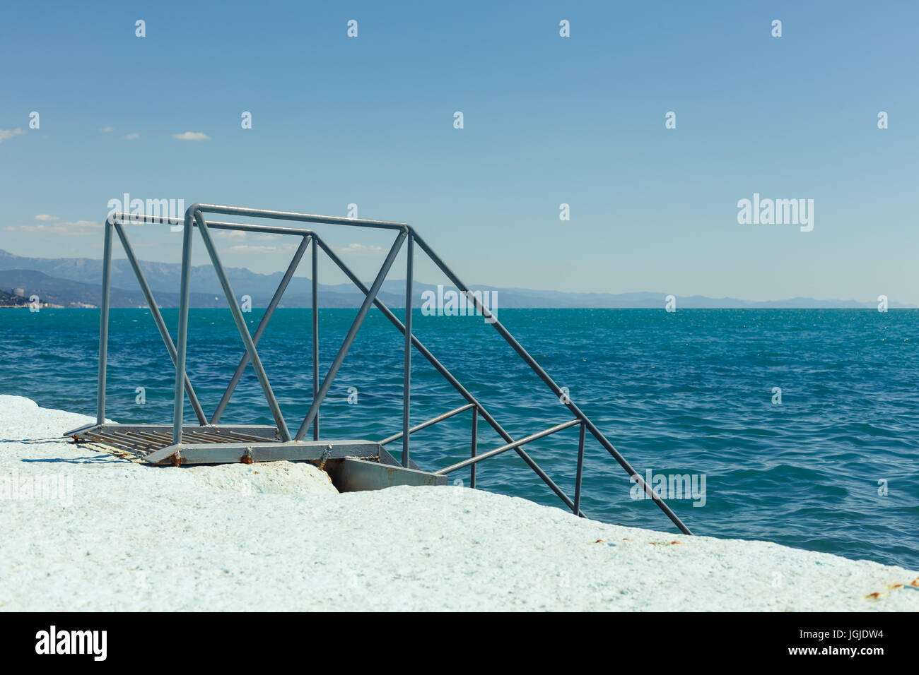 Sea, beach, sky and rails for support when entering the sea Stock Photo ...