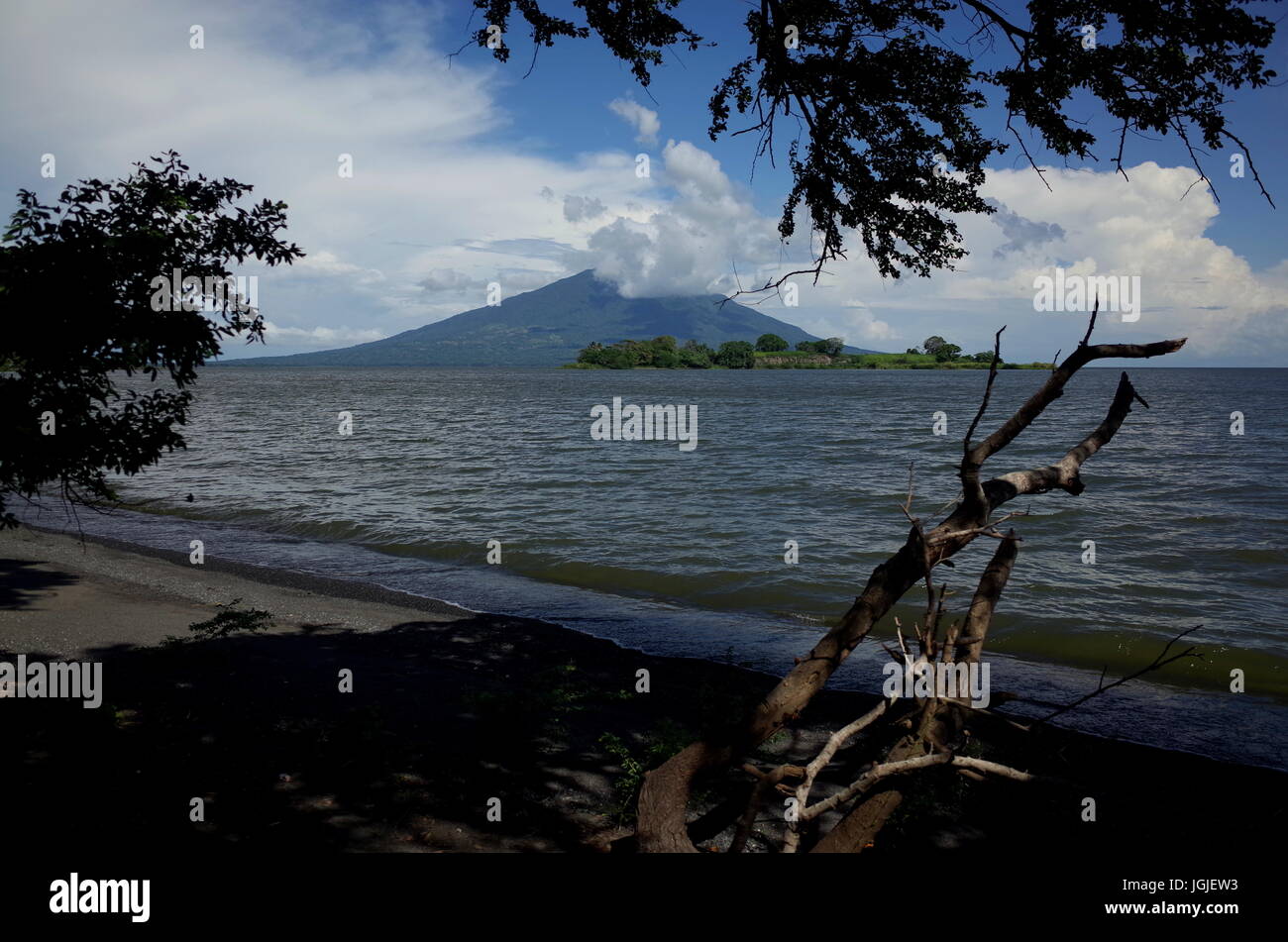 A view of Volcan Maderas from the black volcanic sand beach of Isla ...