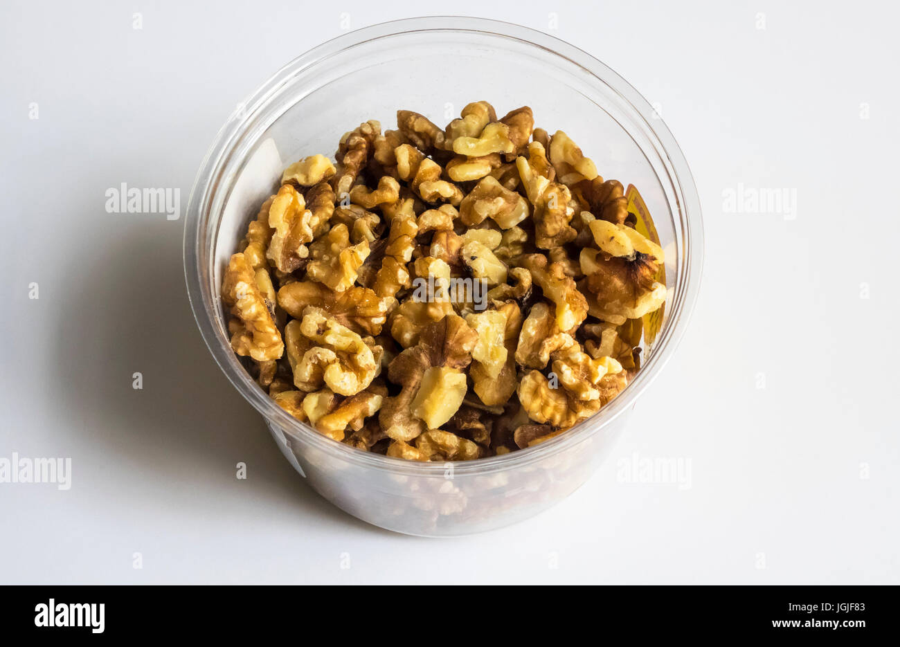 Shelled walnuts in a clear plastic container on a white table Stock ...