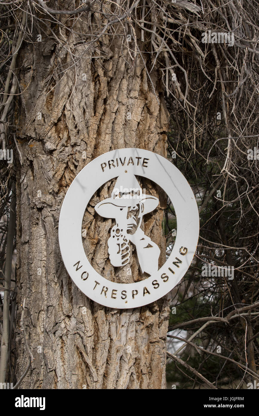 No trespassing sign with cowboy with gun on tree Stock Photo - Alamy