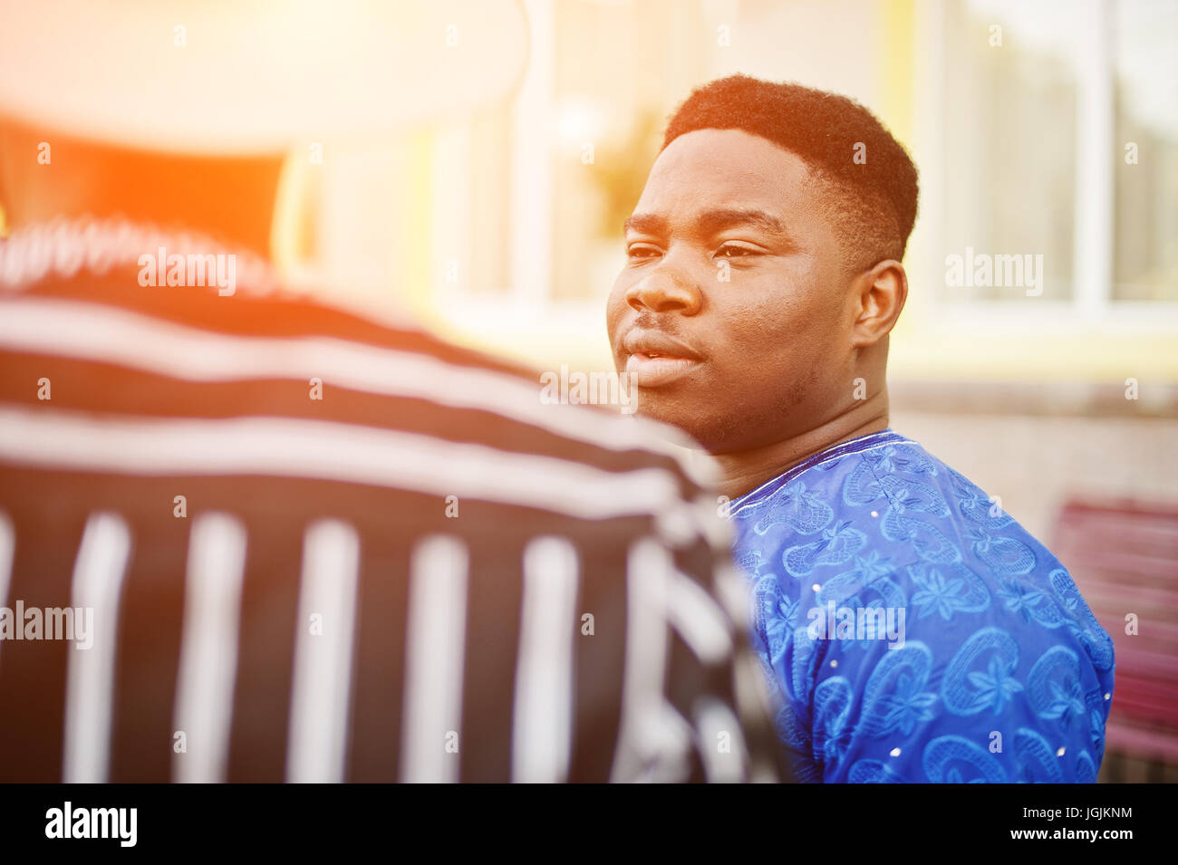 Black men stylishly clothed standing and talking outside on the street ...