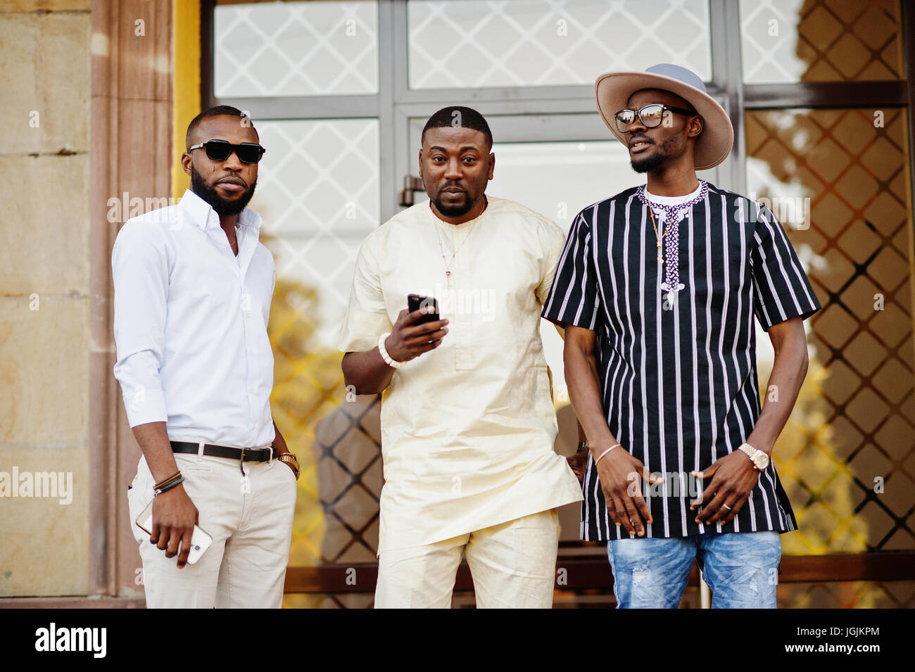 Black men stylishly clothed standing and talking outside on the street ...