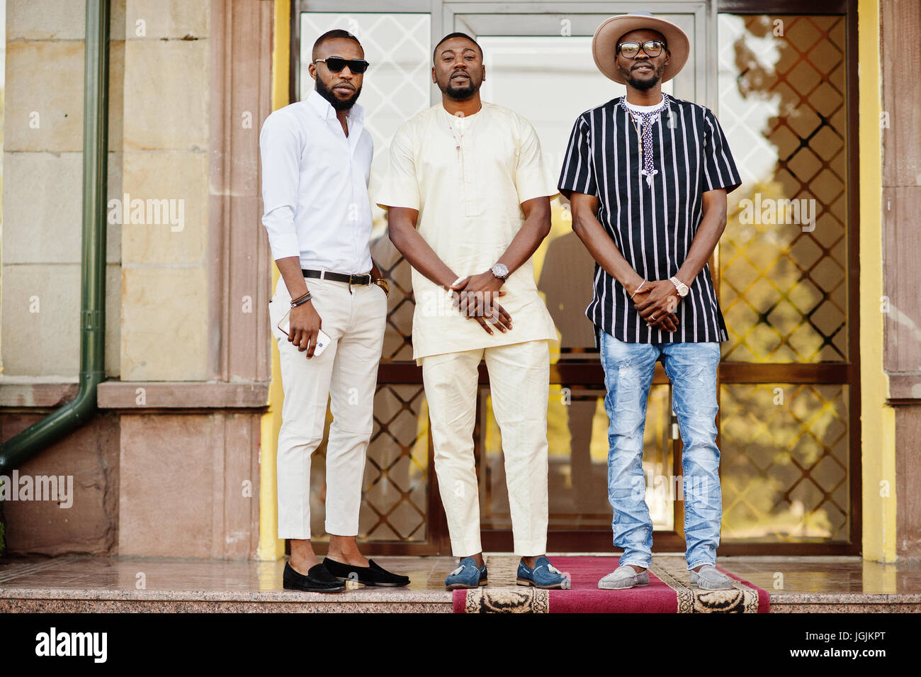 Black men stylishly clothed standing and talking outside on the street ...