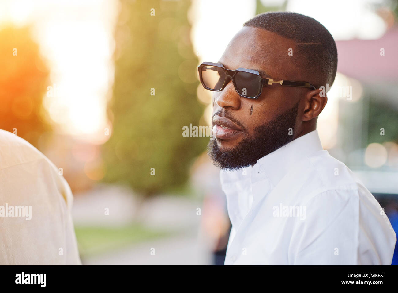 Black men stylishly clothed standing and talking outside on the street ...