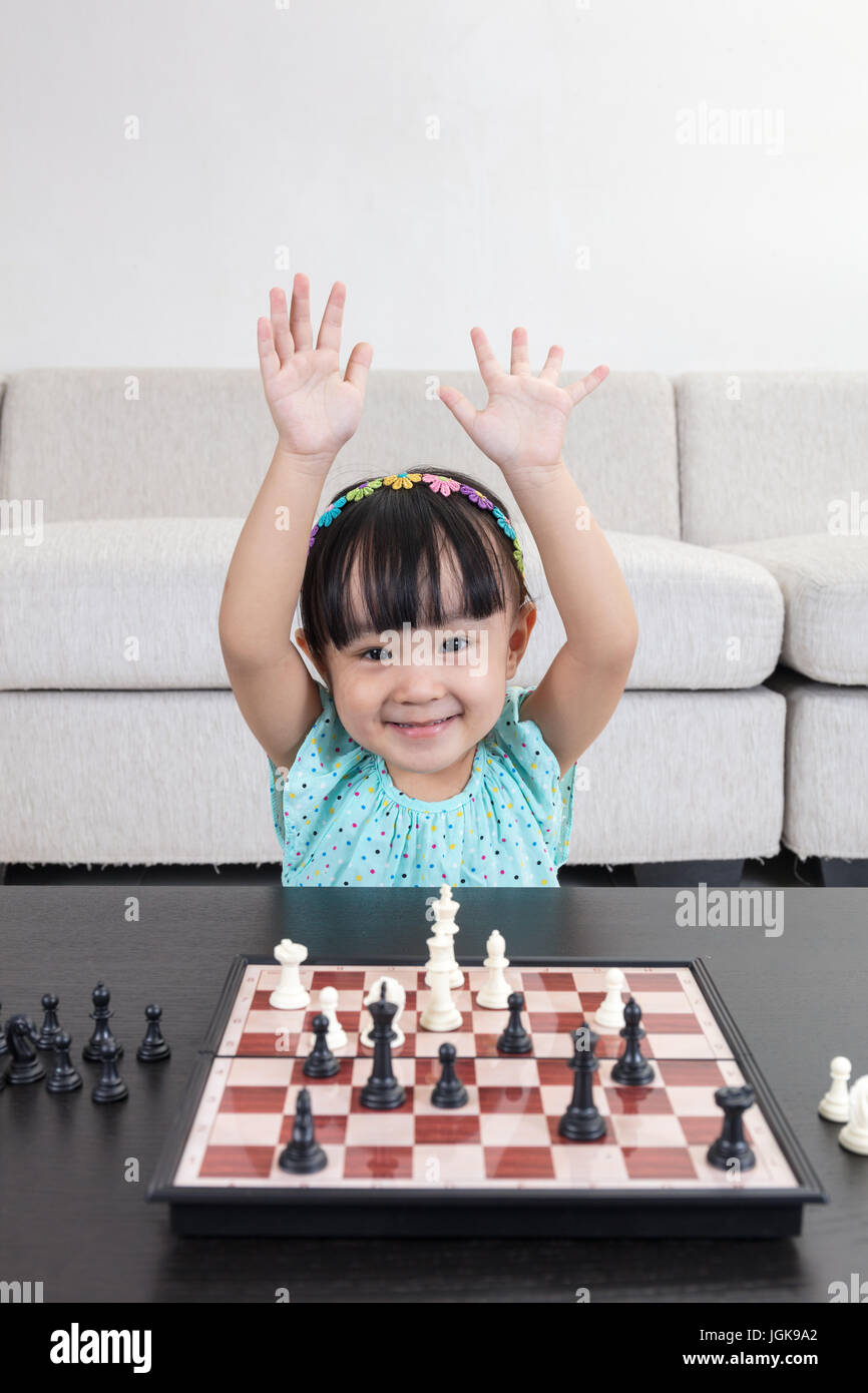 Happy Asian Chinese little girl playing chess chess in the living room ...