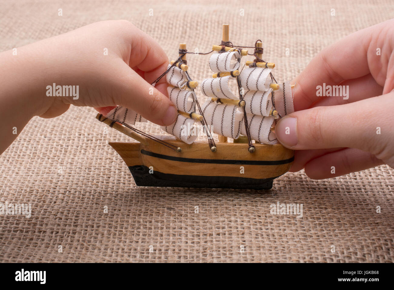 Hand made sail boat in hand on canvas Stock Photo - Alamy