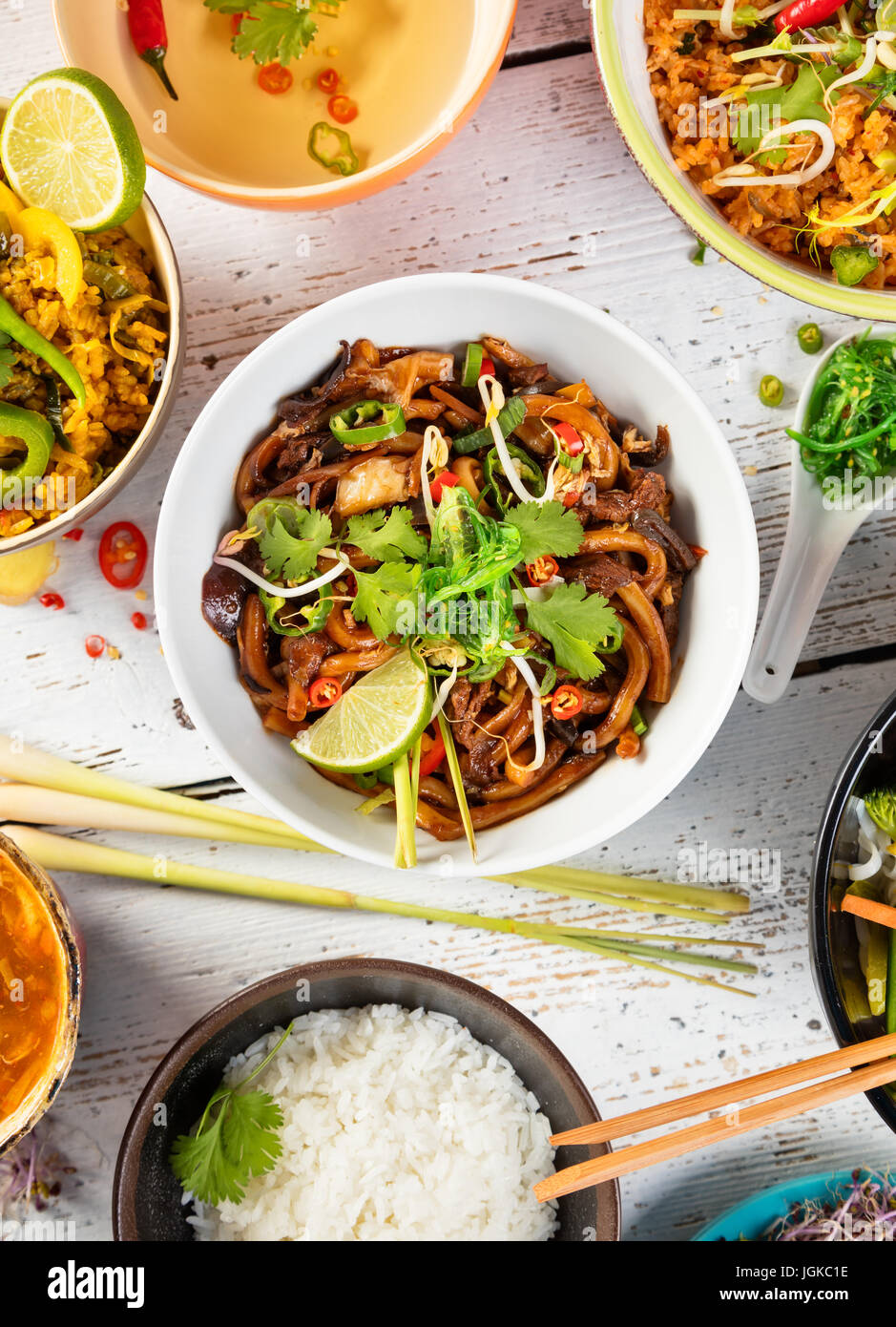 Asian food table with various kind of chinese food, noodles, chicken ...