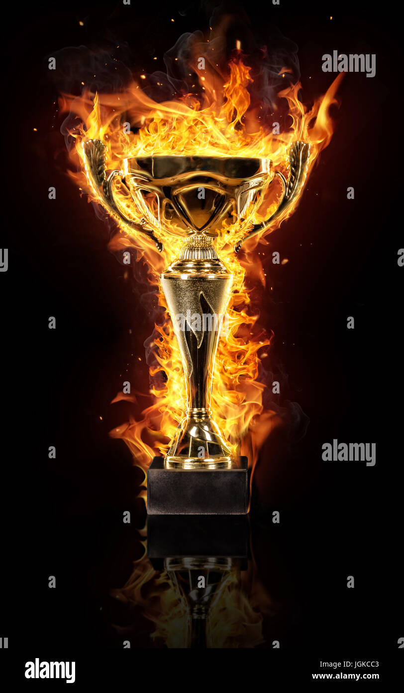 Burning gold trophy cup isolated on black background, flames around ...