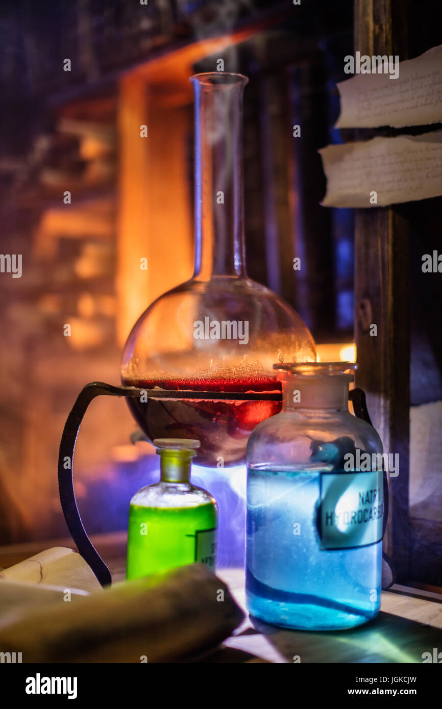 Medieval alchemist laboratory with various kind of flasks and old books ...