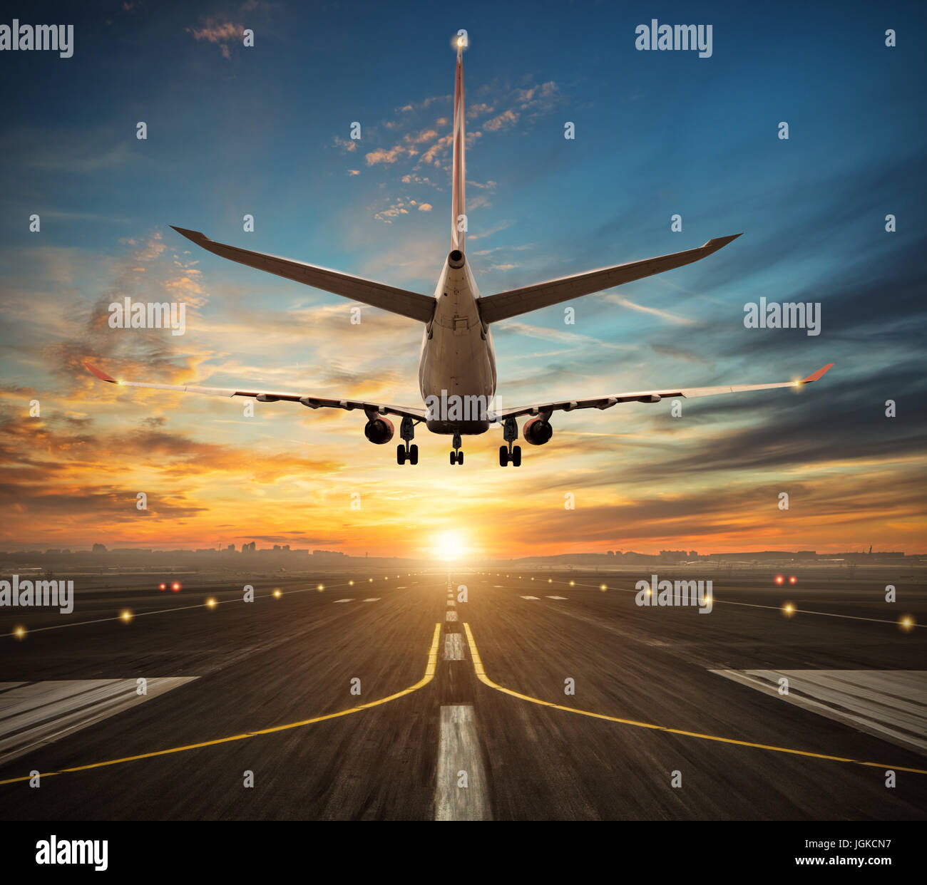 Passengers airplane landing to airport runway in beautiful sunset light ...