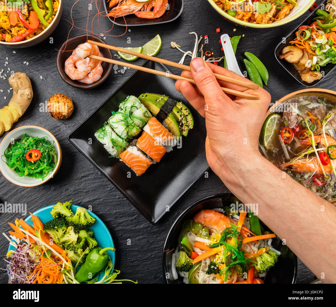 Man hand with chopsticks, eating asian food, top view. Chinese and ...