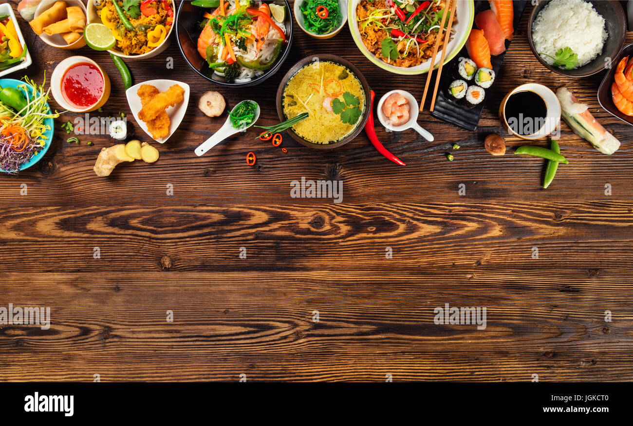 Asian food served on old wooden table, top view, space for text ...