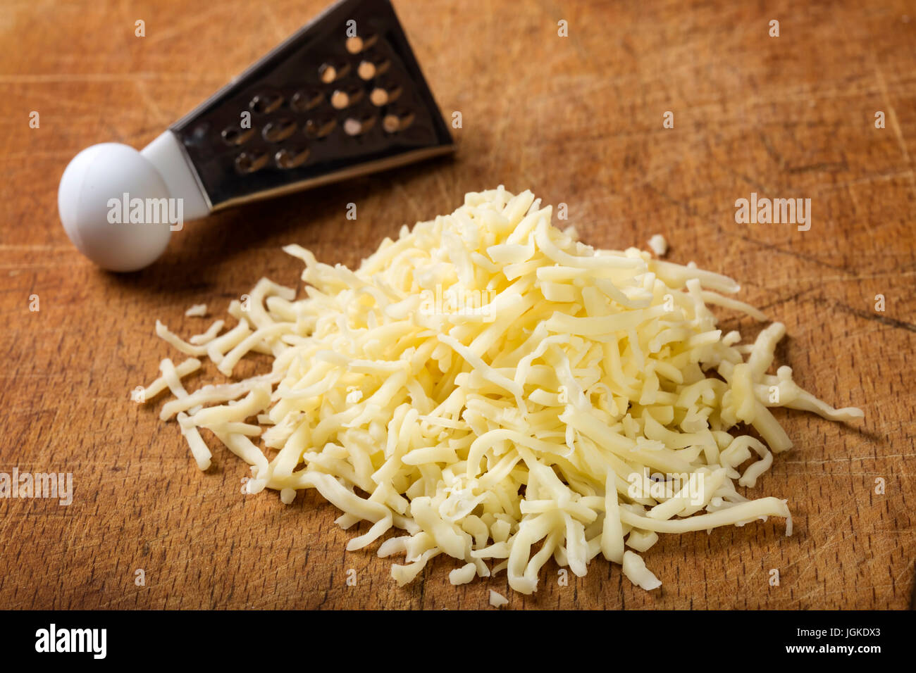 grated parmesan cheese and metal grater on wooden board Stock Photo - Alamy