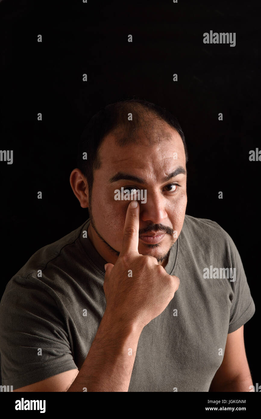 Man with finger pointing eye Stock Photo - Alamy