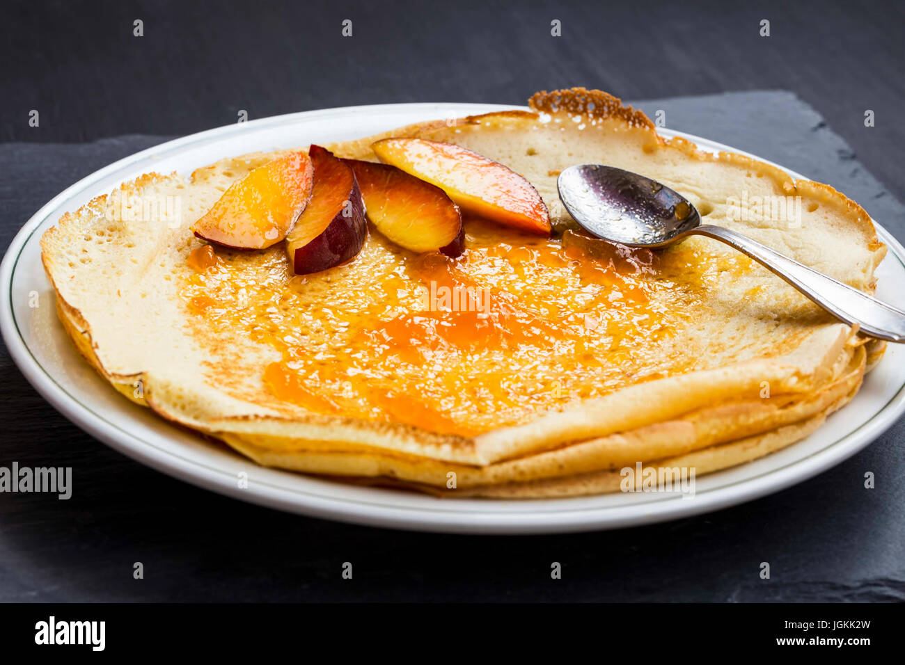 Crepes with apricot jam filling and peach slices Stock Photo - Alamy