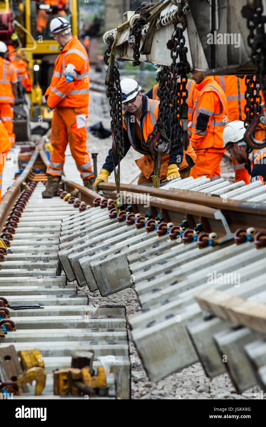 Railway construction workers laying new track Stock Photo - Alamy