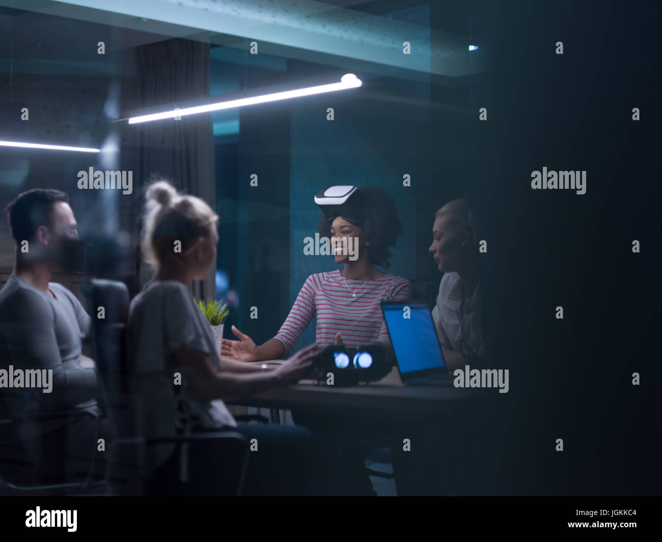Multiethnic Business team using virtual reality headset in night office ...