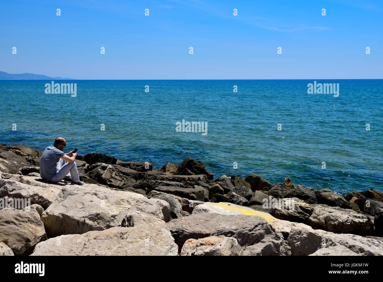 Man looking sitting rocks hi-res stock photography and images - Alamy
