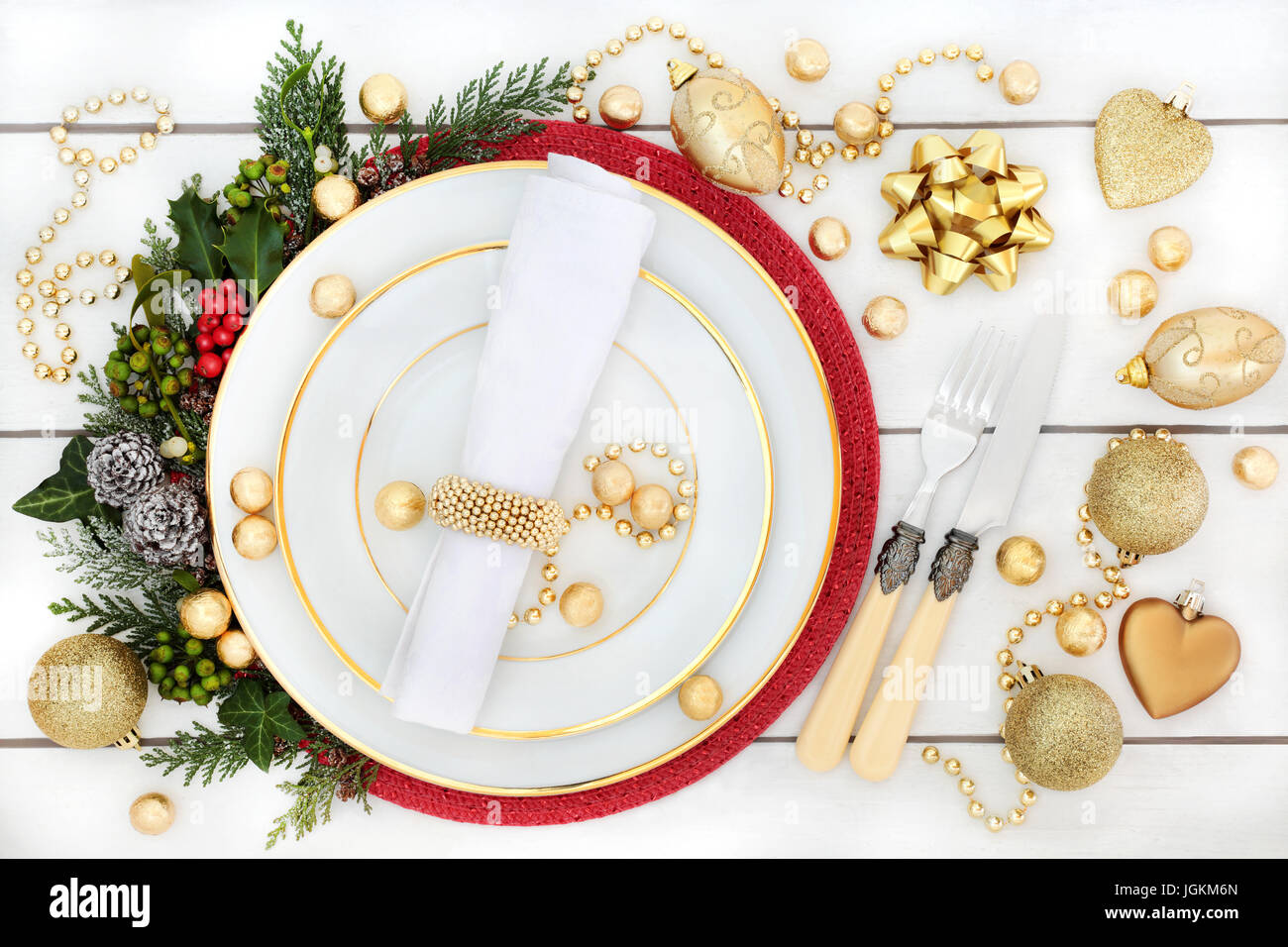 Christmas dinner place setting with porcelain plates, gold bauble ...