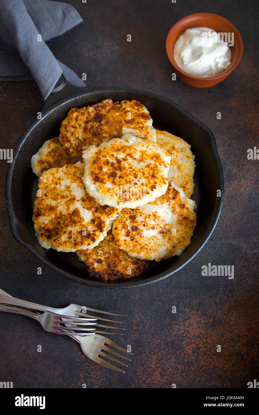 Rustic homemade curd pancakes in cast iron pan with yogurt sauce for ...