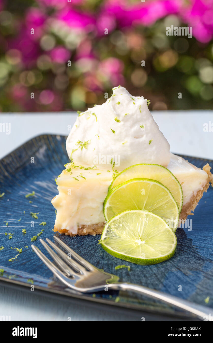 A slice of key lime pie served with whipped cream and lime zest Stock ...