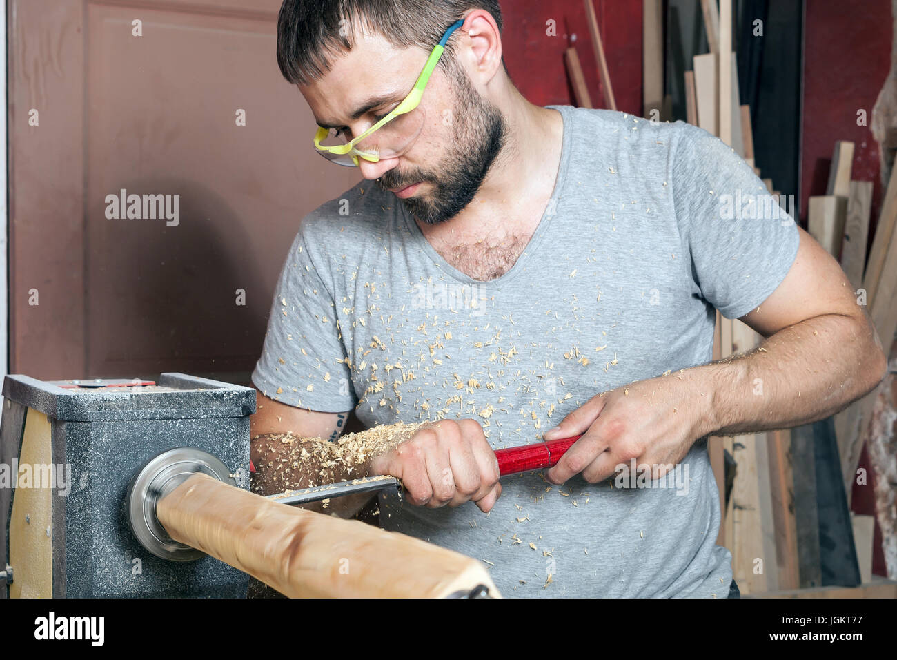 A young brunette man a builder in green protective goggles, a gray T ...
