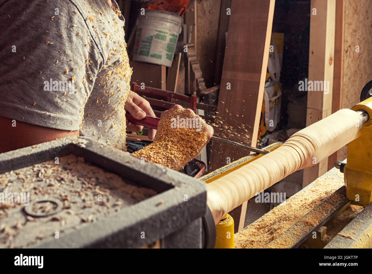A young male construction worker carpenter processes a wood d on a ...
