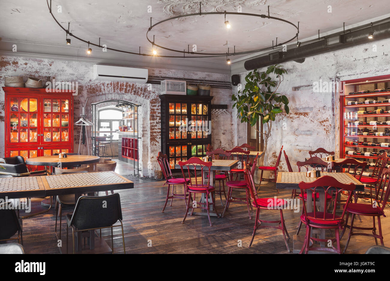 The interior of a modern loft-style café with red chairs, wooden stalls ...