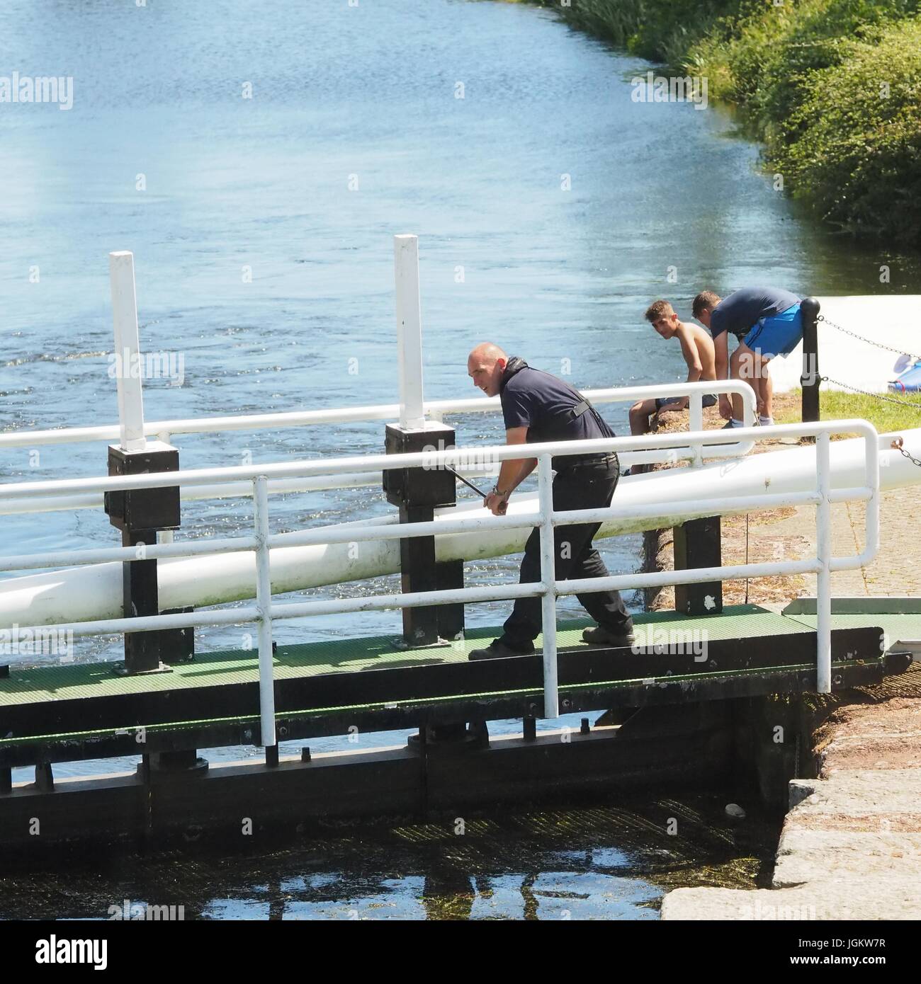 Lock attendant opening lock gear to empty pound lock on Exeter canal ...