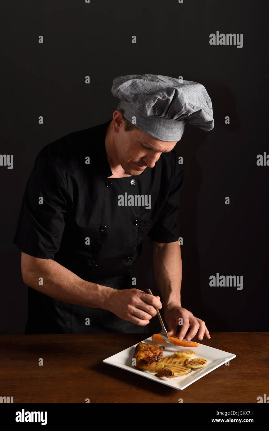 chef preparing a chicken dish with garnish Stock Photo - Alamy