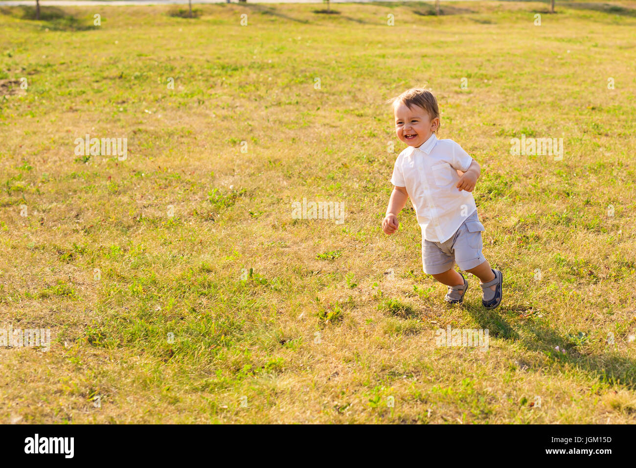 Happy baby boy running on summer field Stock Photo - Alamy