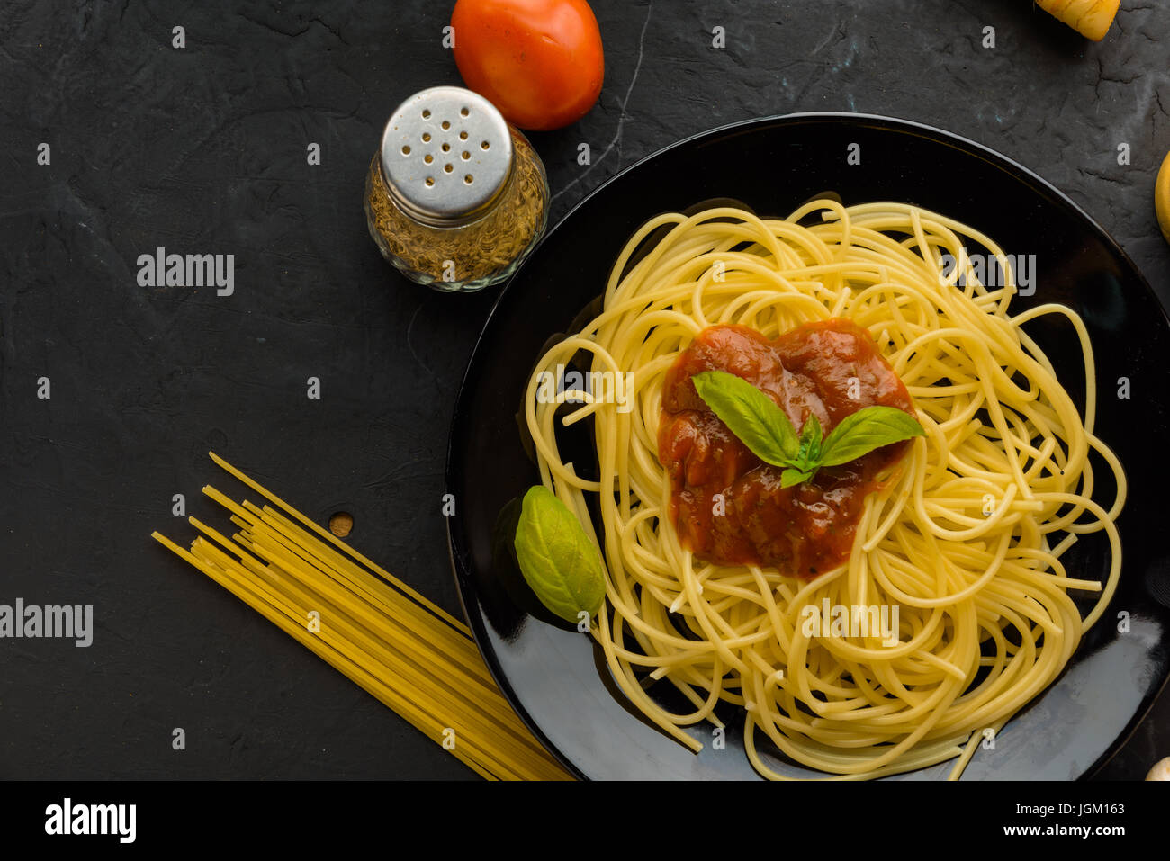 Spaghetti with tomato sauce on the black dish, ready to eat, decoration ...
