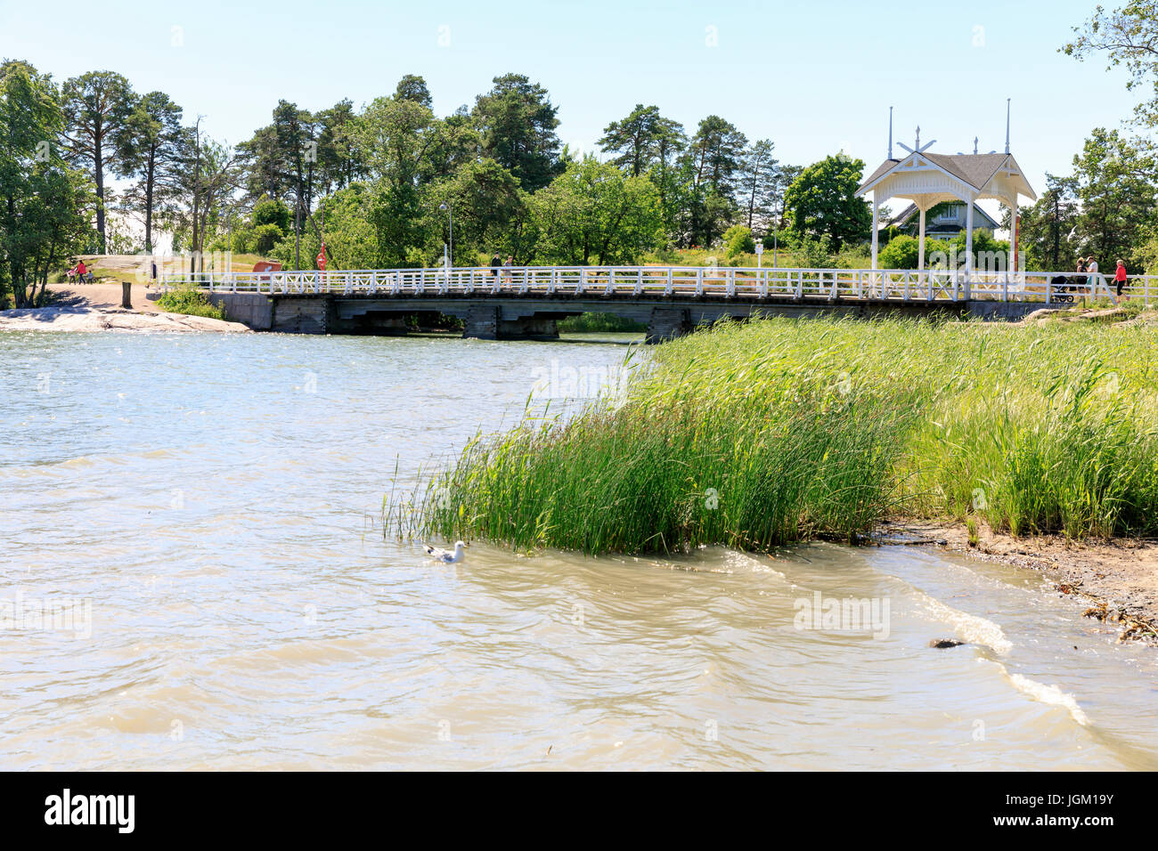 White pedestrian bridge over water between an island and land Stock ...